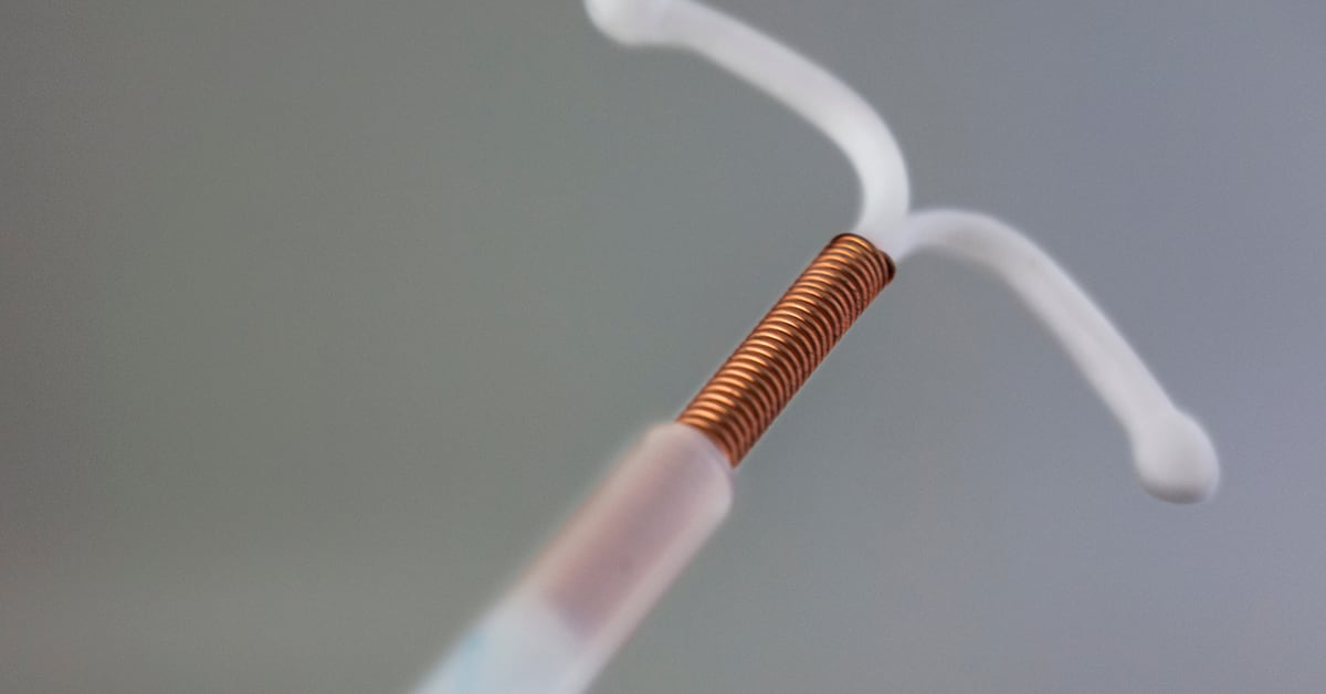 Newborn baby photographed with mother's IUD in hand